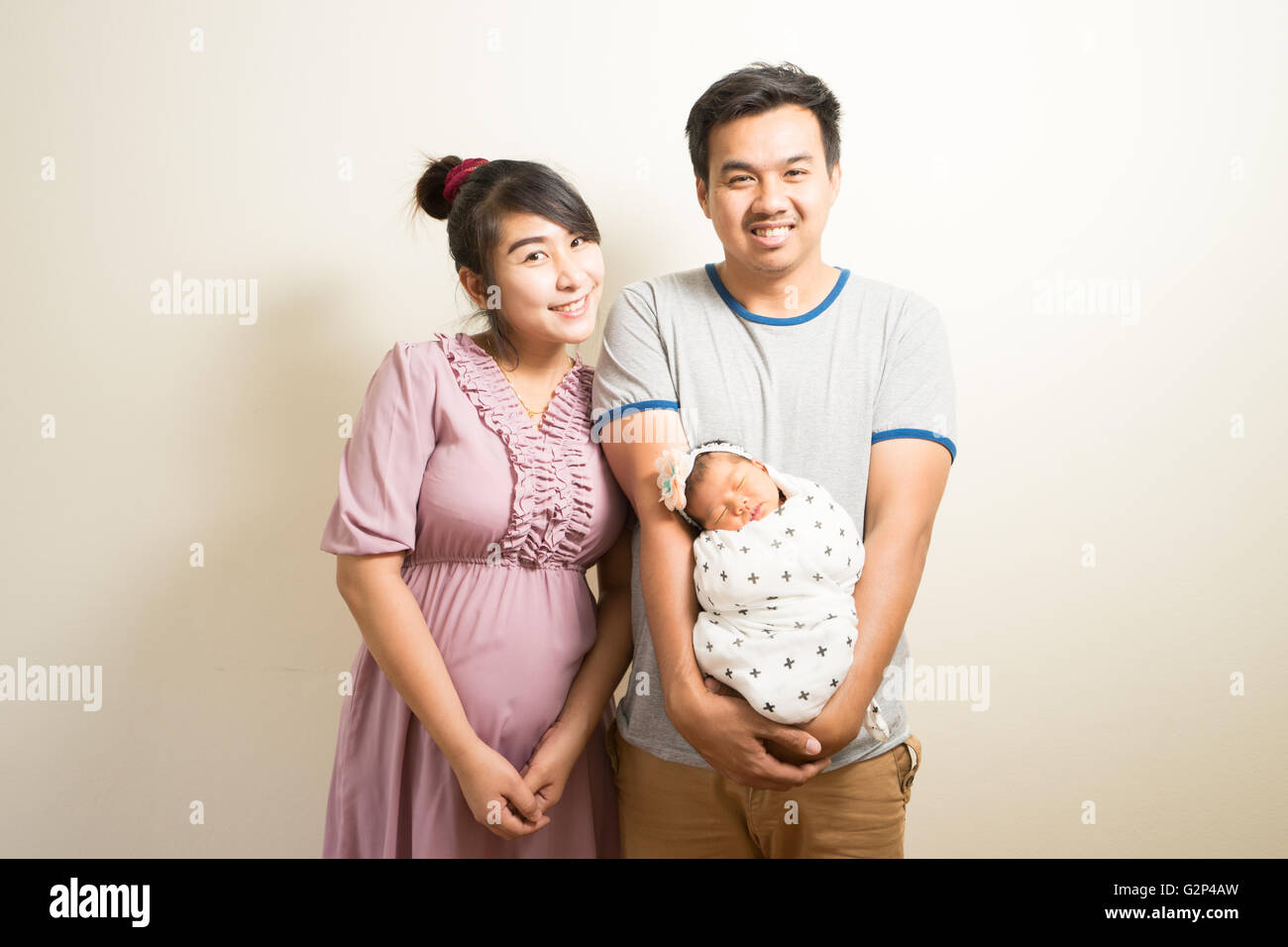 Portrait of Asian parents and six months old baby girl at home. Asian ...