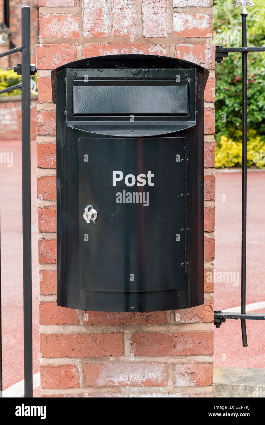 Black post box on a brick wall Stock Photo - Alamy
