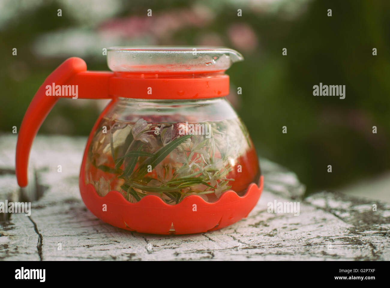 teapot of fruit tea with herbs and berry on the white tree stump Stock ...