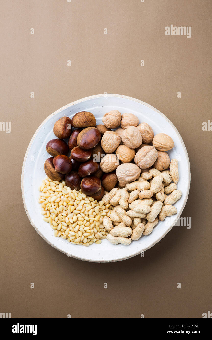 Different types of nuts on a white plate Stock Photo - Alamy