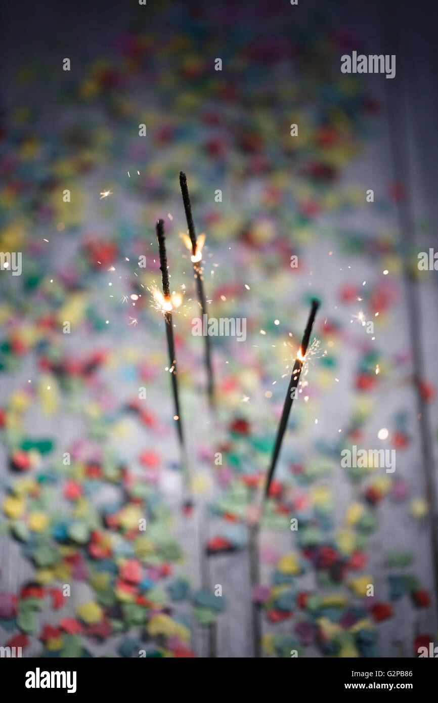 Burning Sparklers with colorful Confetti on wooden Table at a Party ...