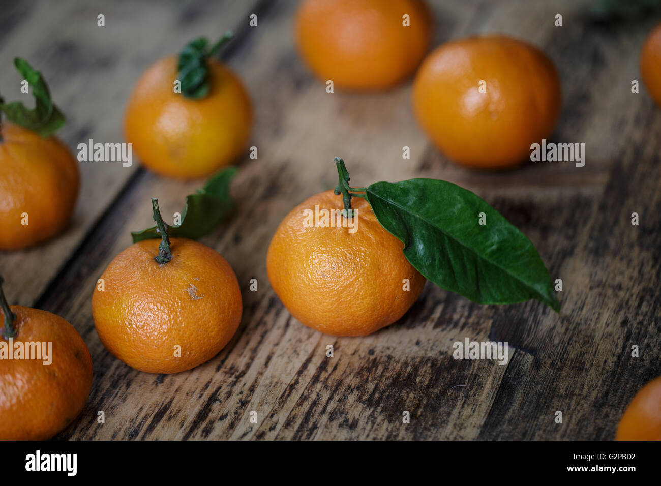 Bright Orange Mandarin with Green Leaf on Rustic Wooden board Stock ...