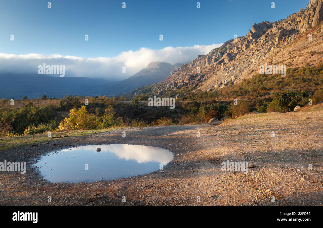 Mountain landscape with blue sky reflection in puddle at sunset Stock ...
