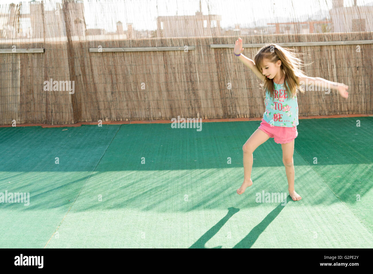girl playing on the terrace on artificial turf Stock Photo - Alamy