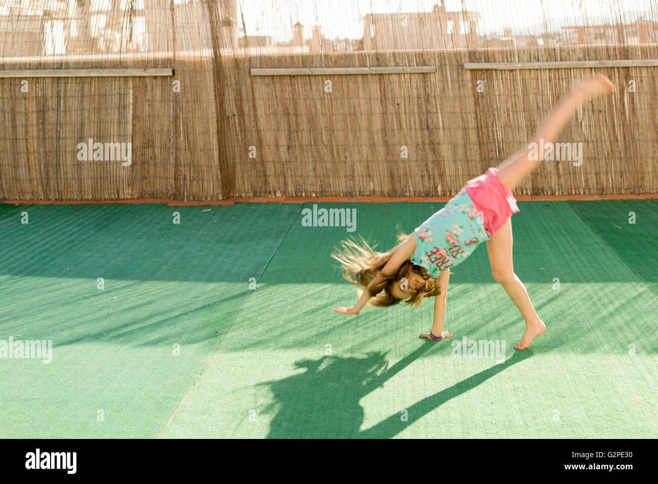 girl playing on the terrace on artificial turf Stock Photo - Alamy