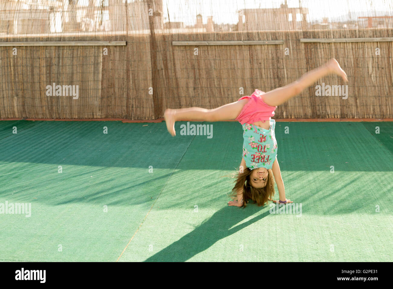 girl playing on the terrace on artificial turf Stock Photo - Alamy