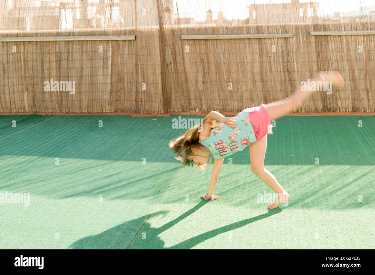 girl playing on the terrace on artificial turf Stock Photo - Alamy