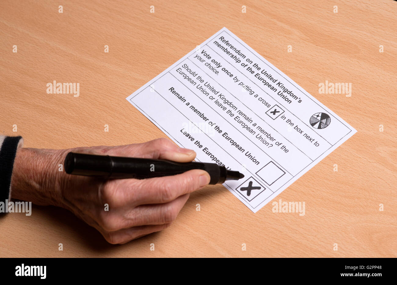 Completing a postal ballot paper with a cross in a box to leave the ...