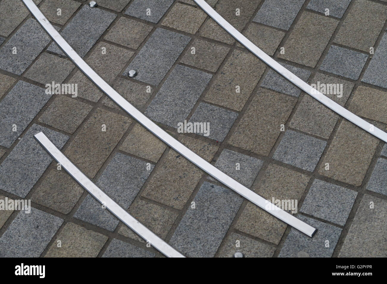 Metal rails make lines, pattern in brick pavement, ground Stock Photo ...