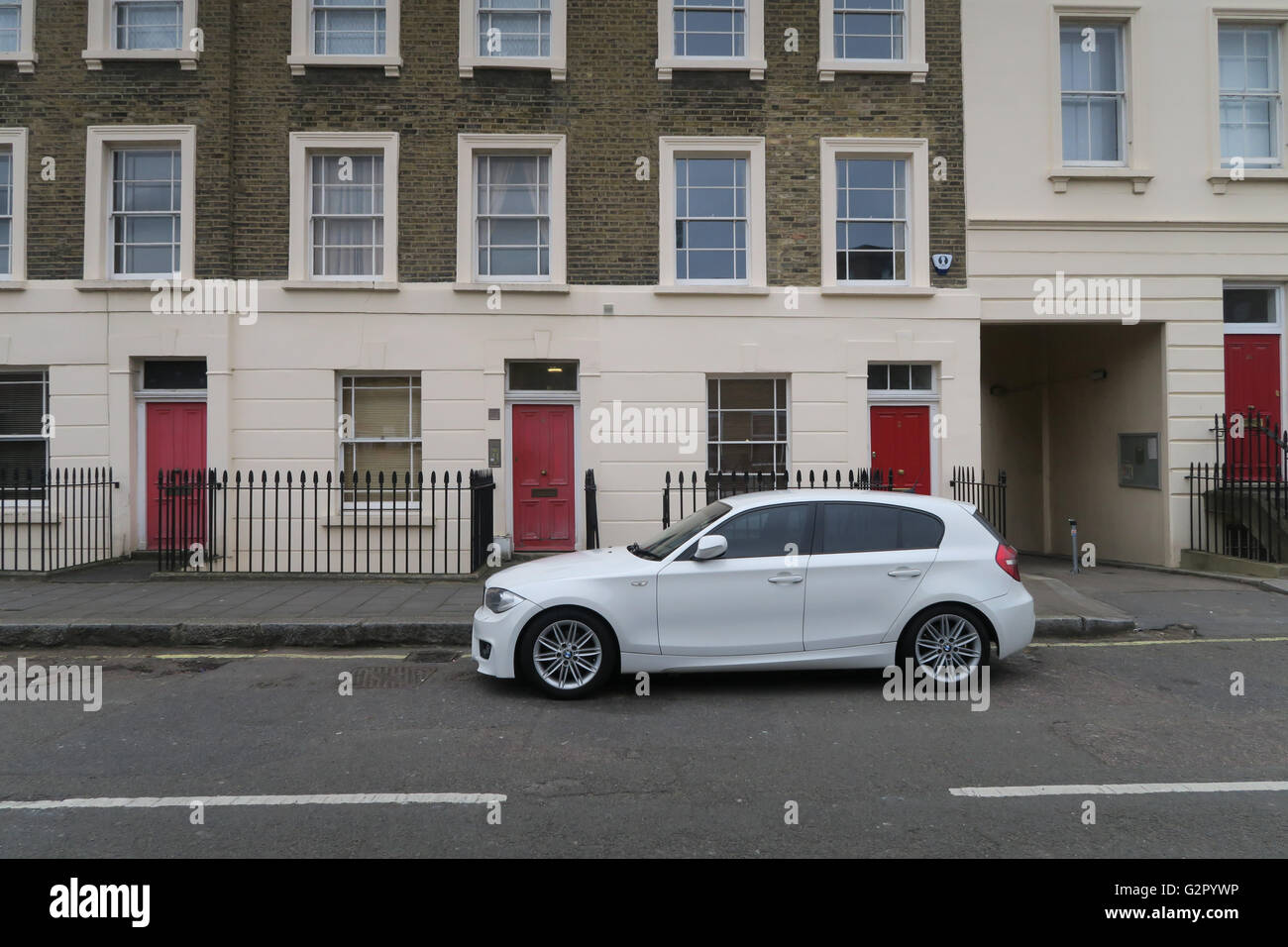 BMW hatchback parked outside red doored houses Stock Photo - Alamy