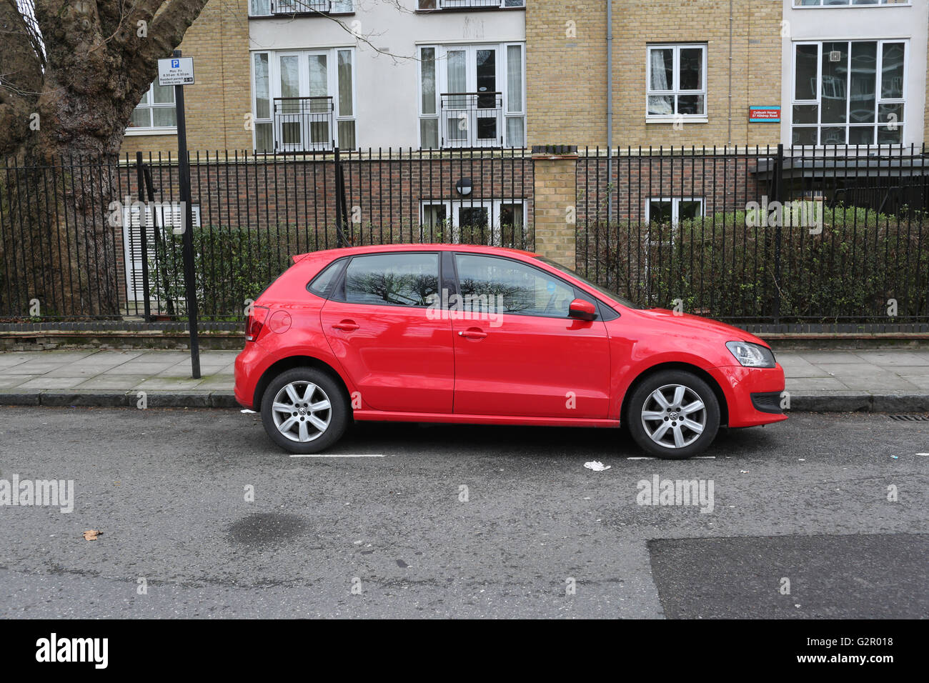 colourful red car parked on street against houses Stock Photo - Alamy