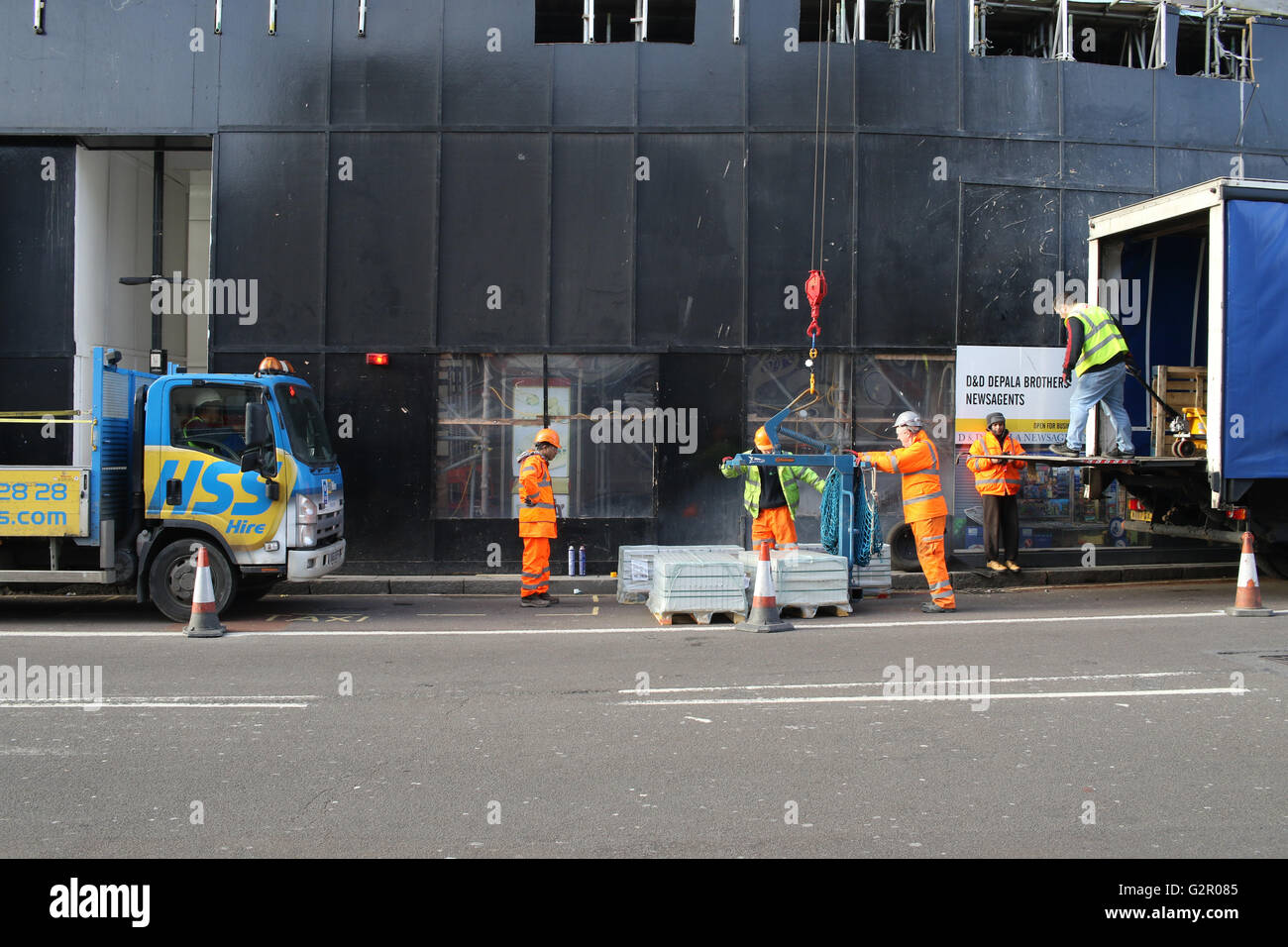 Construction workers unload building materials from a truck ready to be ...