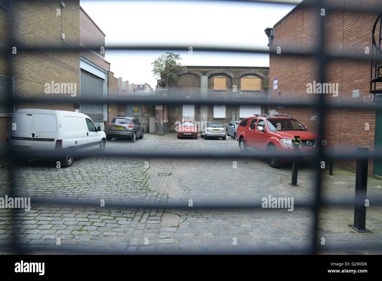 Cars parked in a private lot through a steel fence Stock Photo - Alamy
