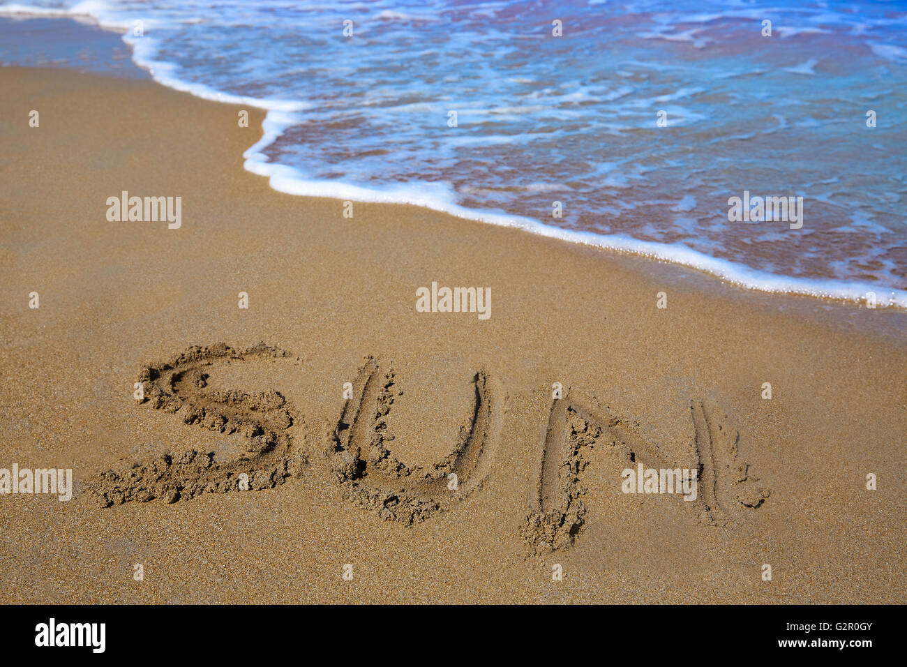 Sun spell written work in sand of a beach in vacation Stock Photo - Alamy
