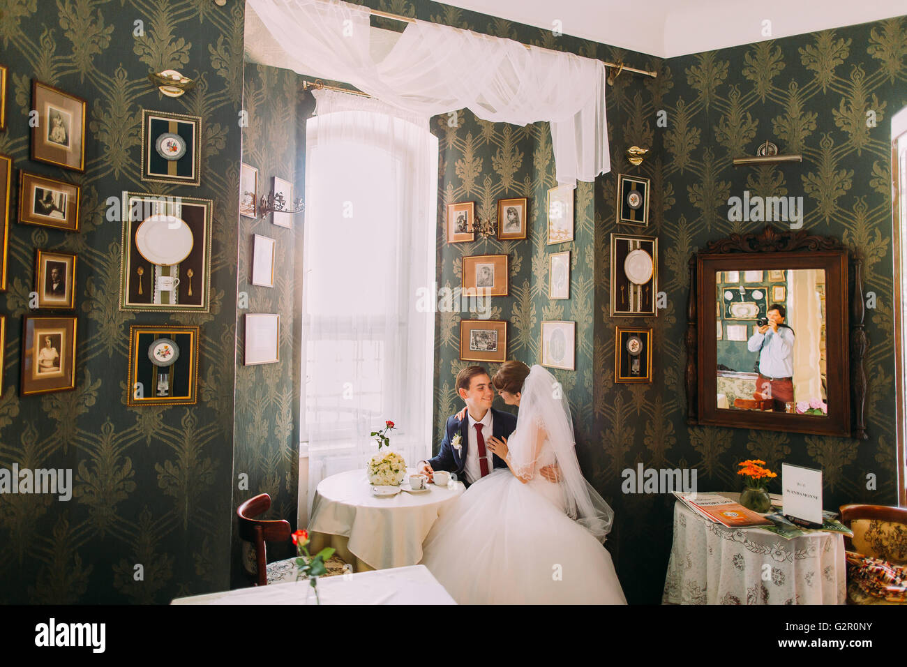 Bride and groom drinking coffee at vintage cafe after their wedding ...