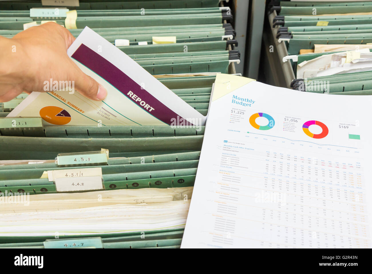 Hand holding report chart file in filing cabinet Stock Photo - Alamy