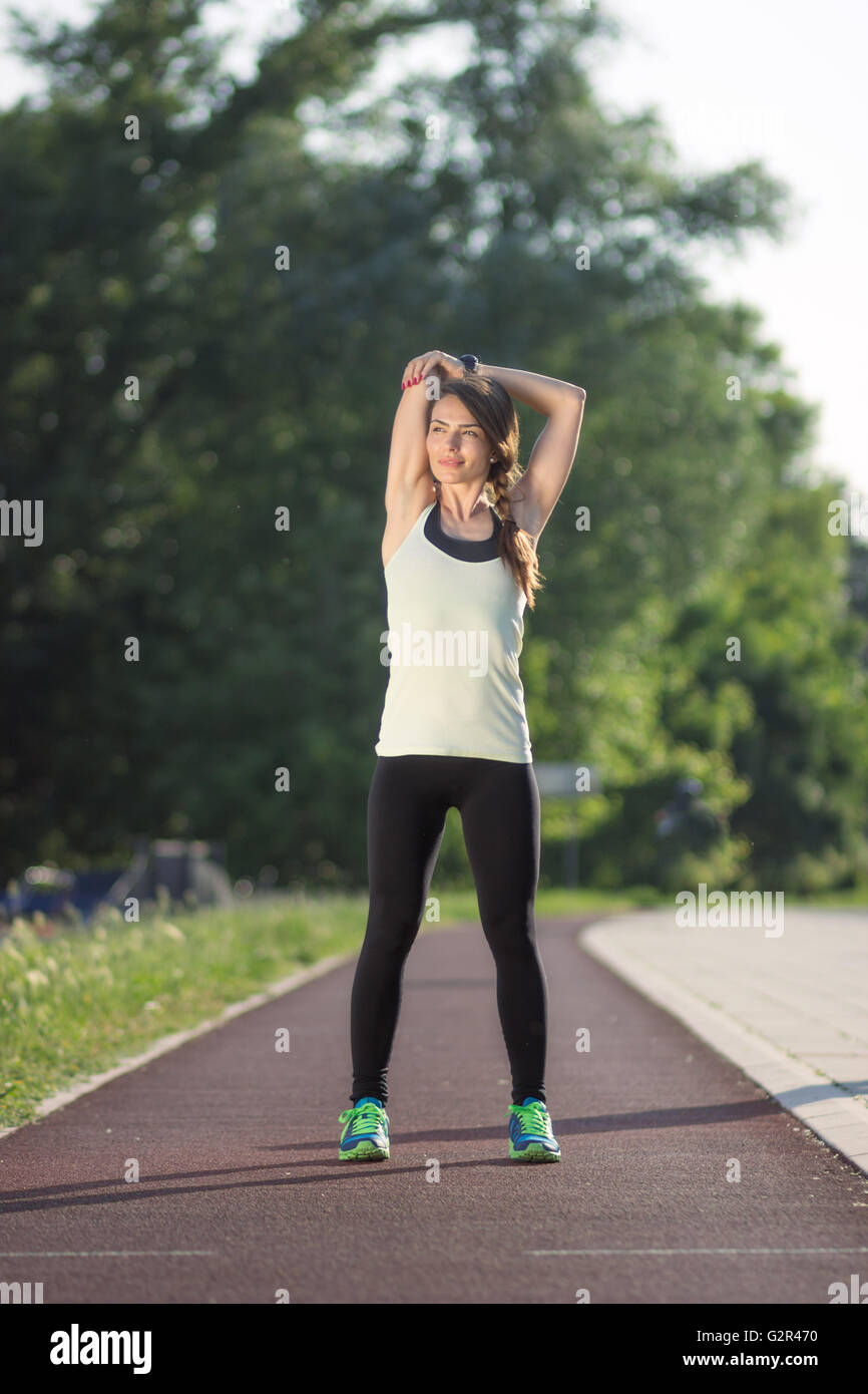 Girl stretch arm, outdoors, track Stock Photo - Alamy