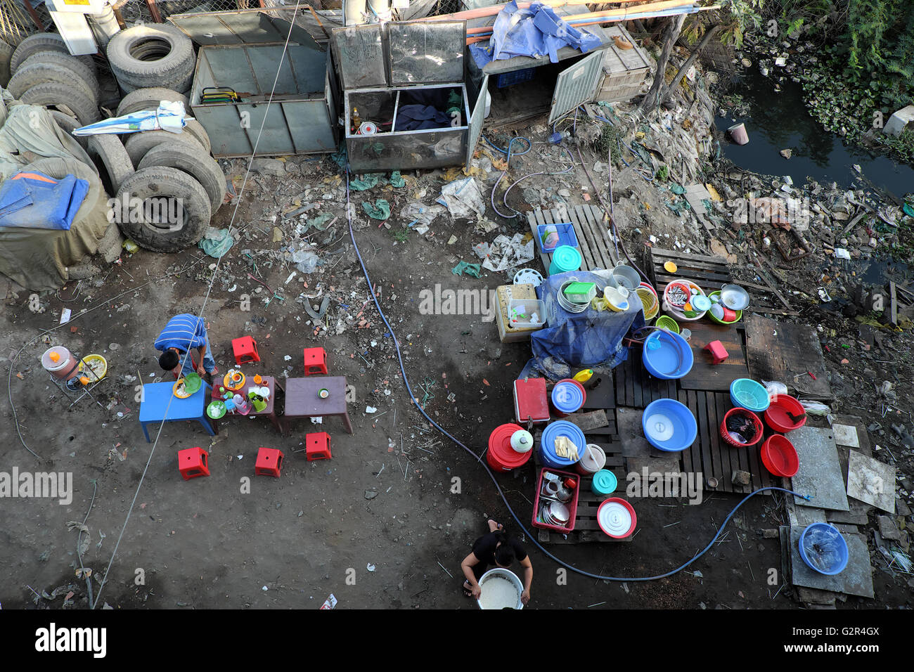 Outdoor restaurant at polluted river, full of rubbish, trash, pollution ...