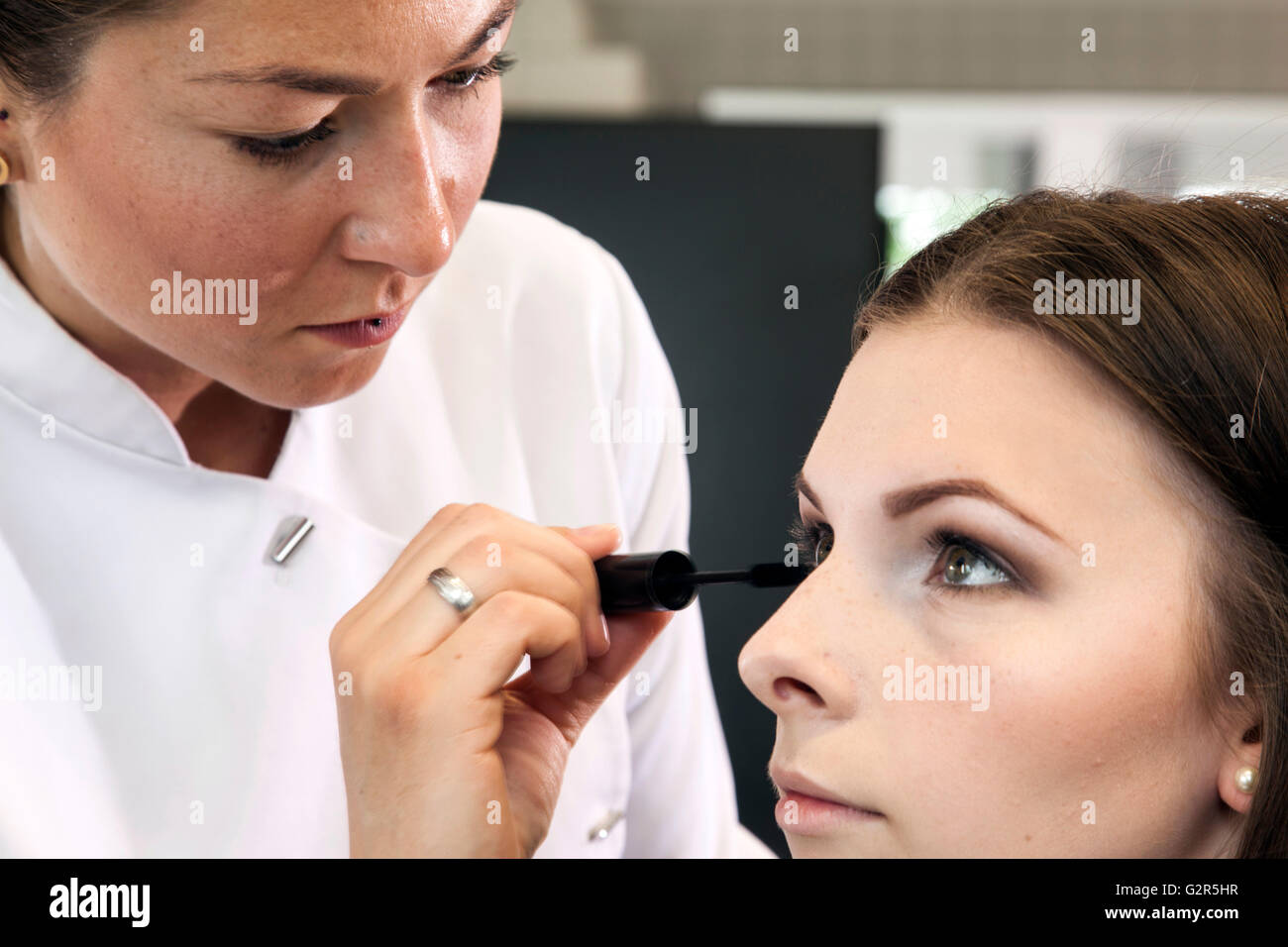 Beautician makeup a young woman Stock Photo - Alamy