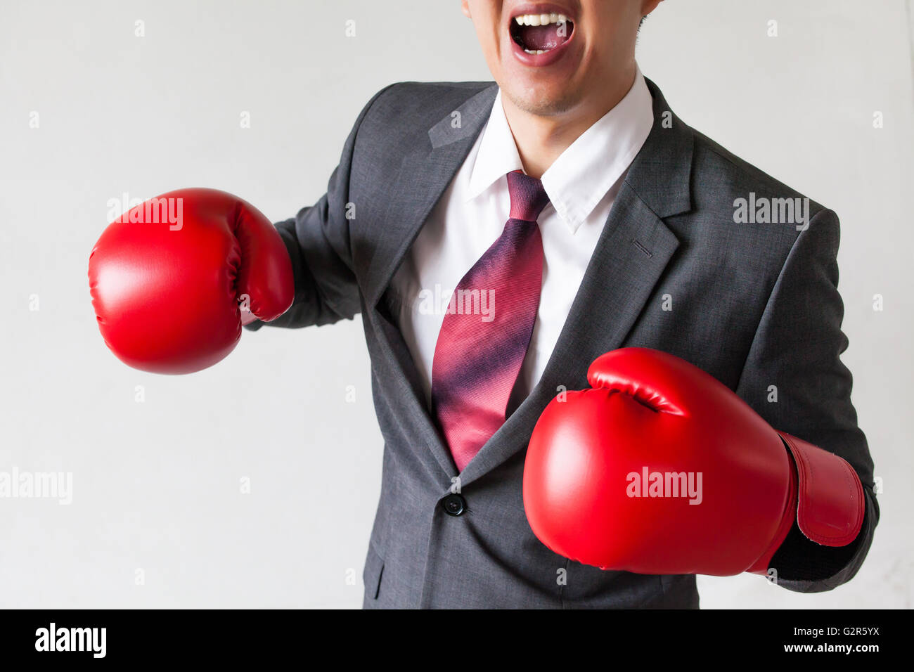 Businessman in boxing gloves launching a punch isolated on white ...