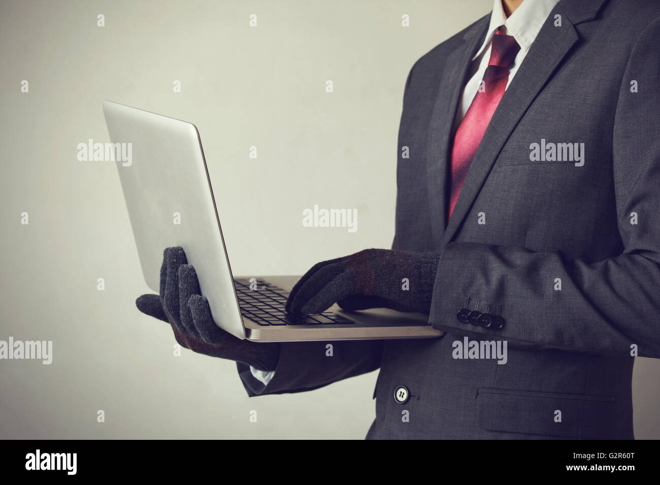 Business man wearing gloves and using computer - fraud, hacker, theft ...