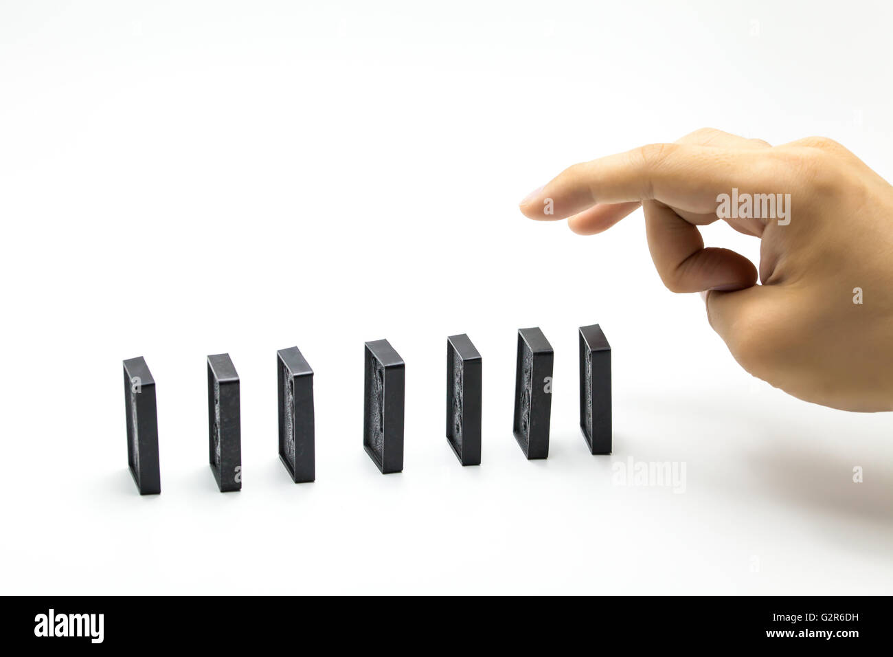 Hand pushing dominoes isolated on white background - domino effect ...