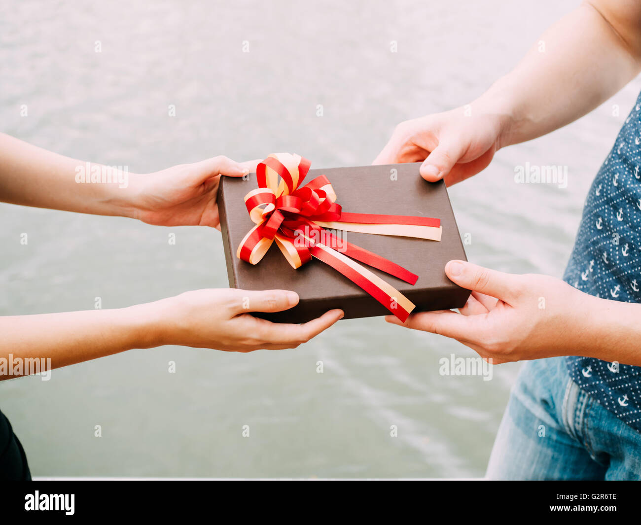Couple giving a gift box to each other. Happy relationship in outdoor ...