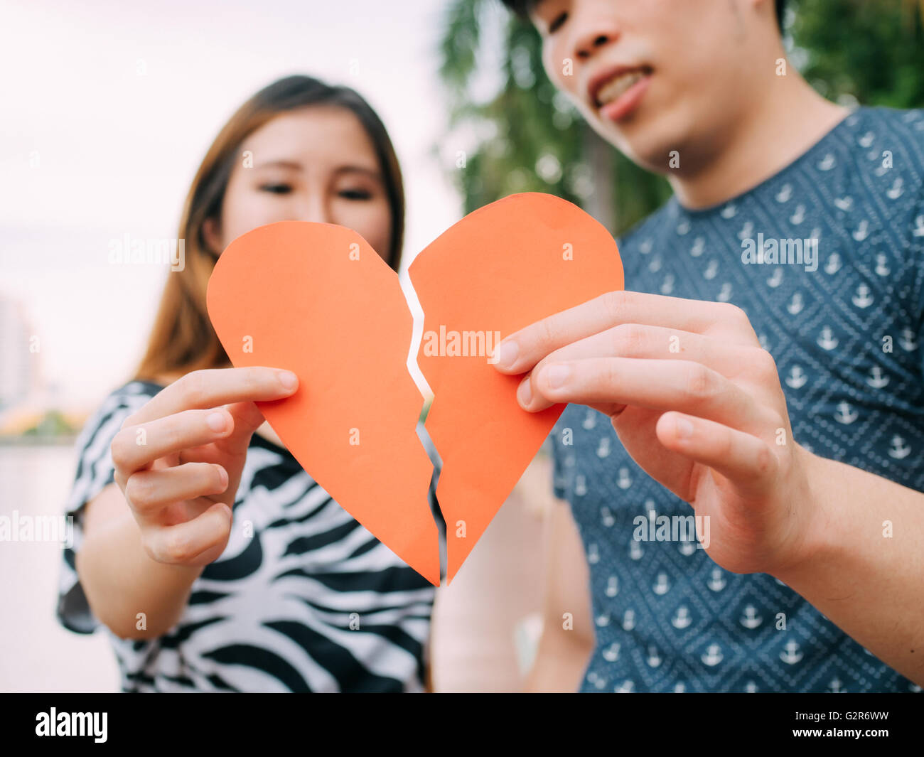Couple trying to connect two pieces of paper heart - relationship, in ...