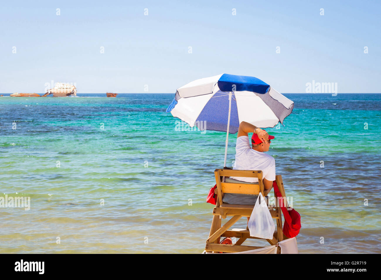 Sunny Mediterranean beach, lifeguard sitting in observation post, on ...
