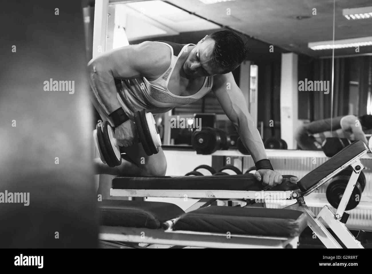 Handsome young muscled man working out with dumbbells in gym Stock ...