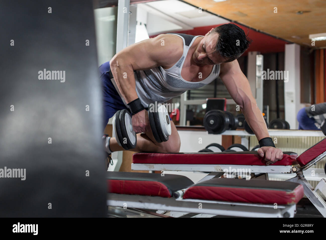 Handsome young muscled man working out with dumbbells in gym Stock ...