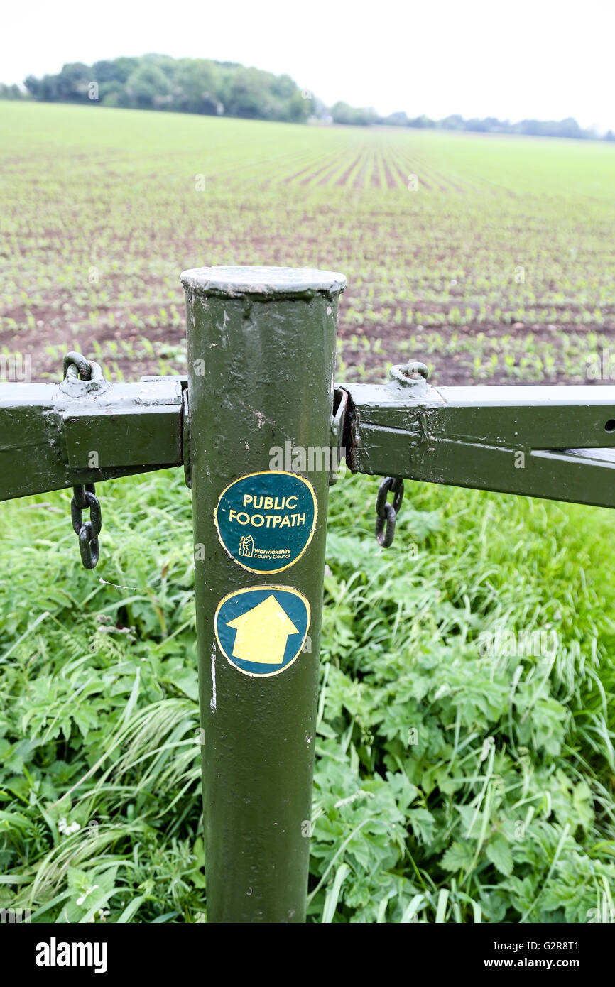 A public footpath or right of way sign points directly into a farm ...