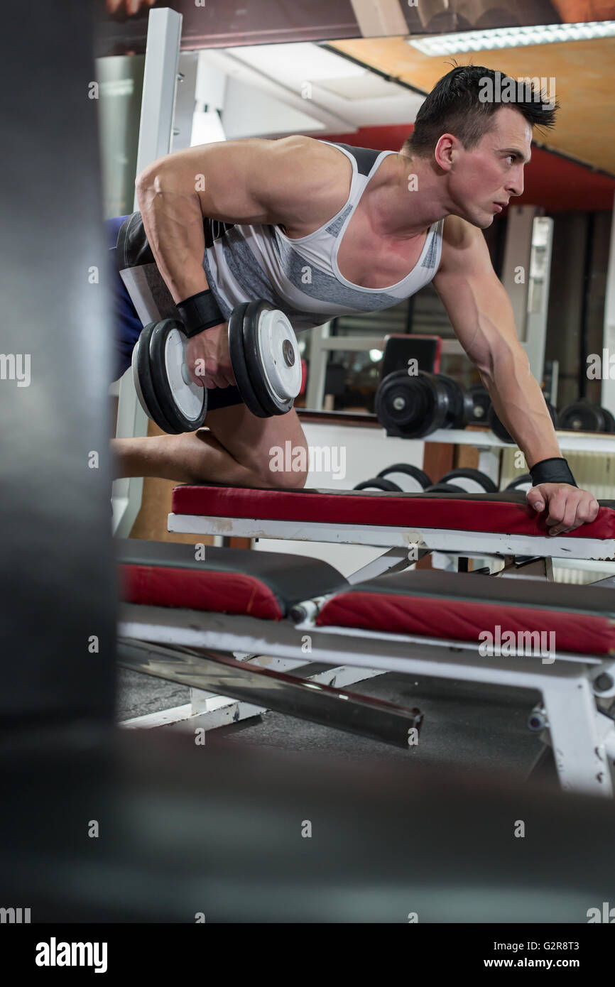 Handsome young muscled man working out with dumbbells in gym Stock ...