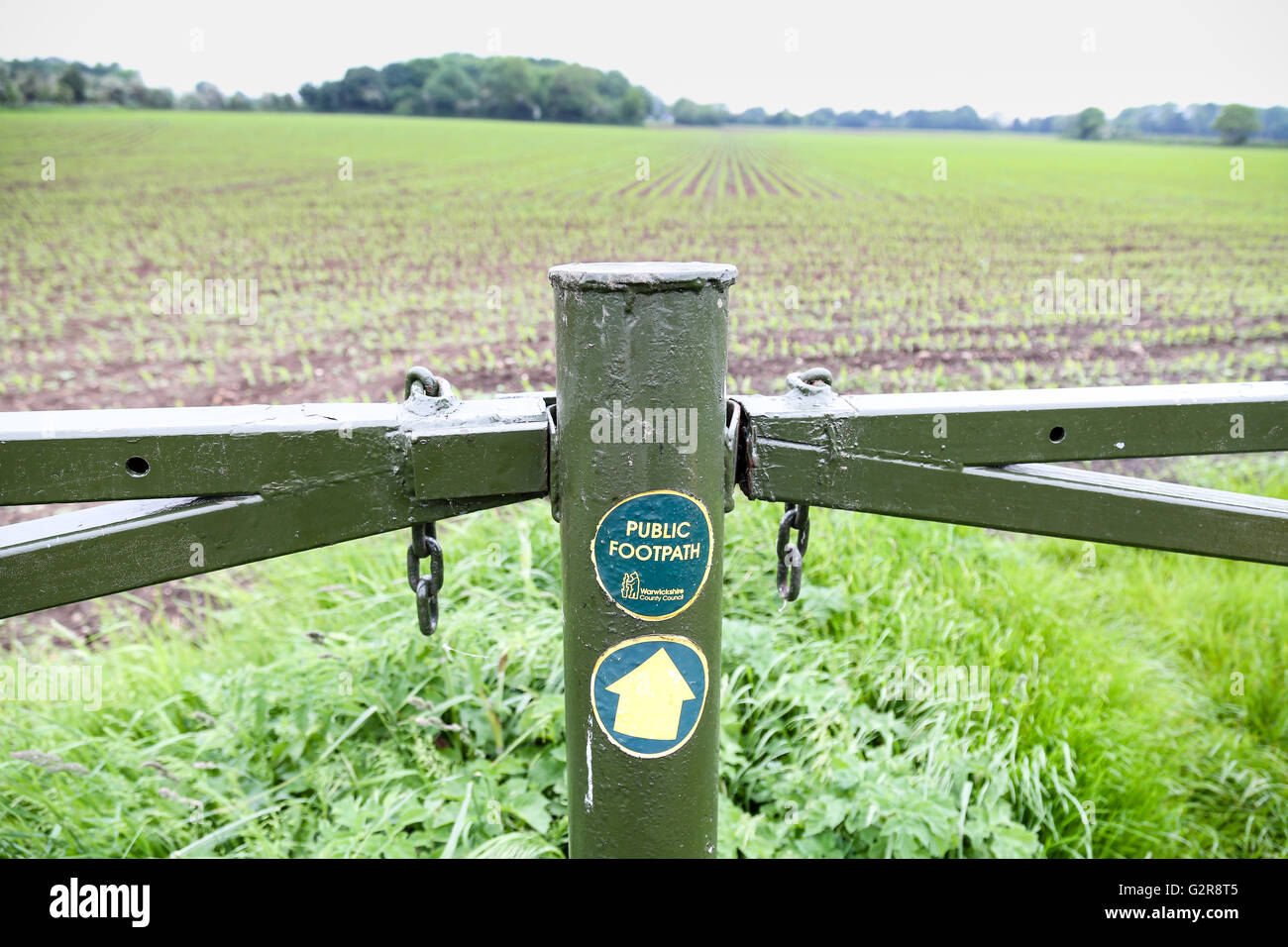 A public footpath or right of way sign points directly into a farm ...