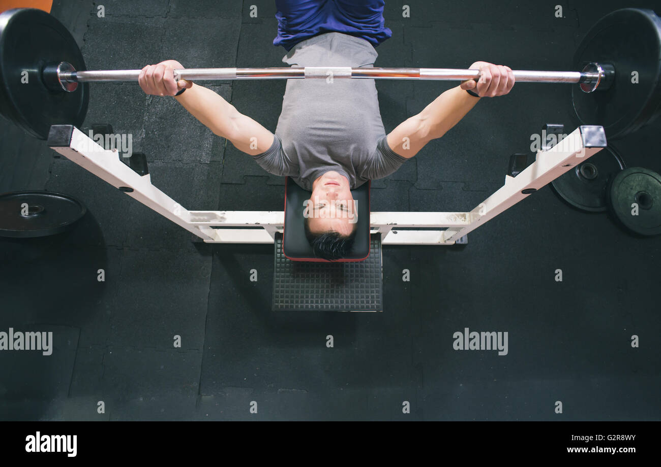 Top view of attractive young muscular man lifting weight while working ...