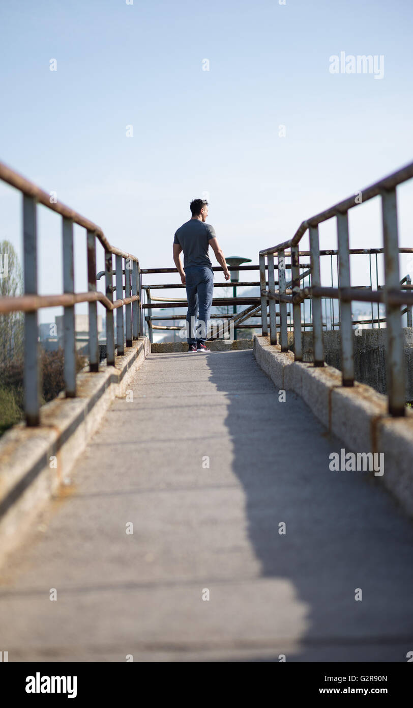 Tired after jogging. Concentrated young man resting after running while ...