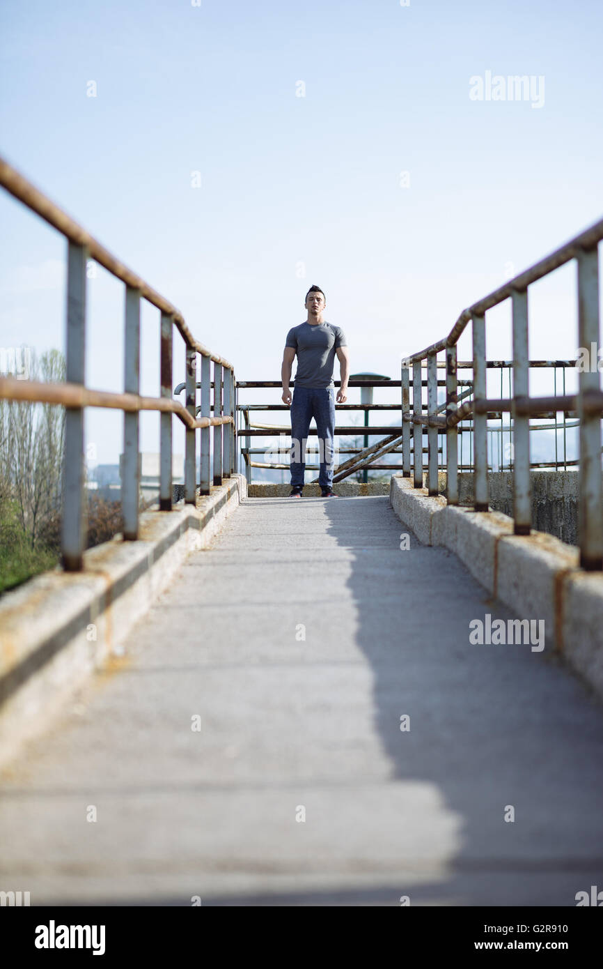 Tired after jogging. Concentrated young man resting after running while ...