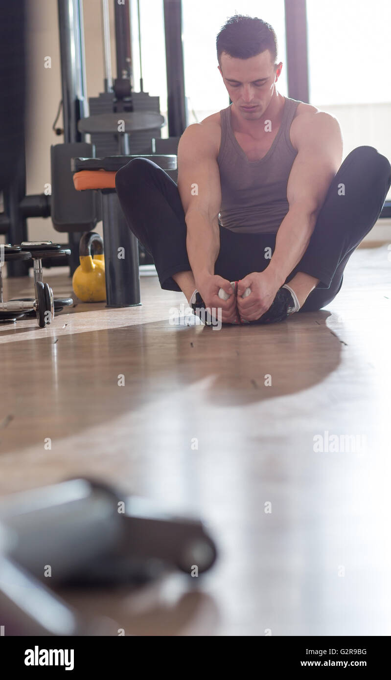 Handsome muscular man doing stretching exercise Stock Photo - Alamy