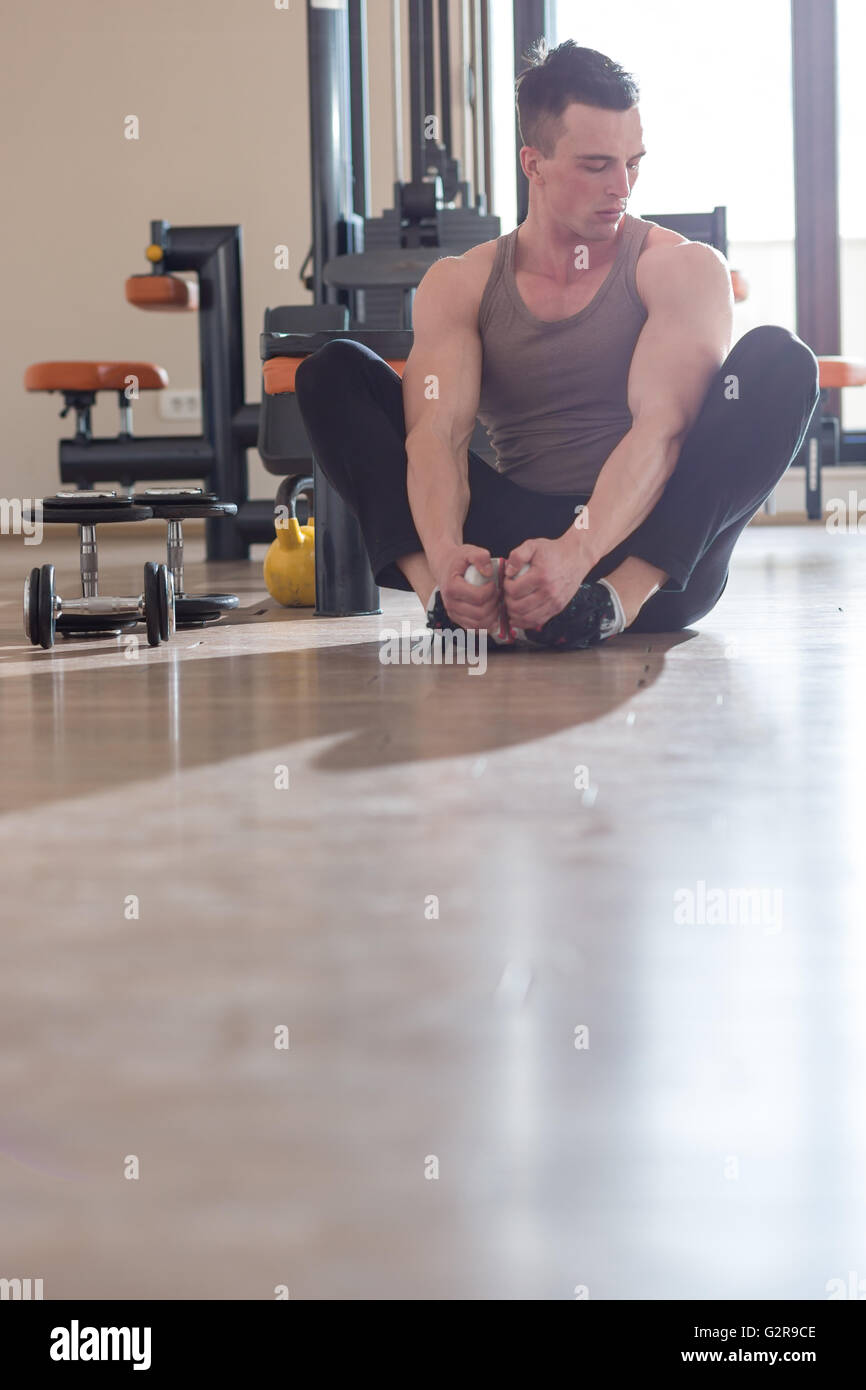 Handsome muscular man doing stretching exercise Stock Photo - Alamy