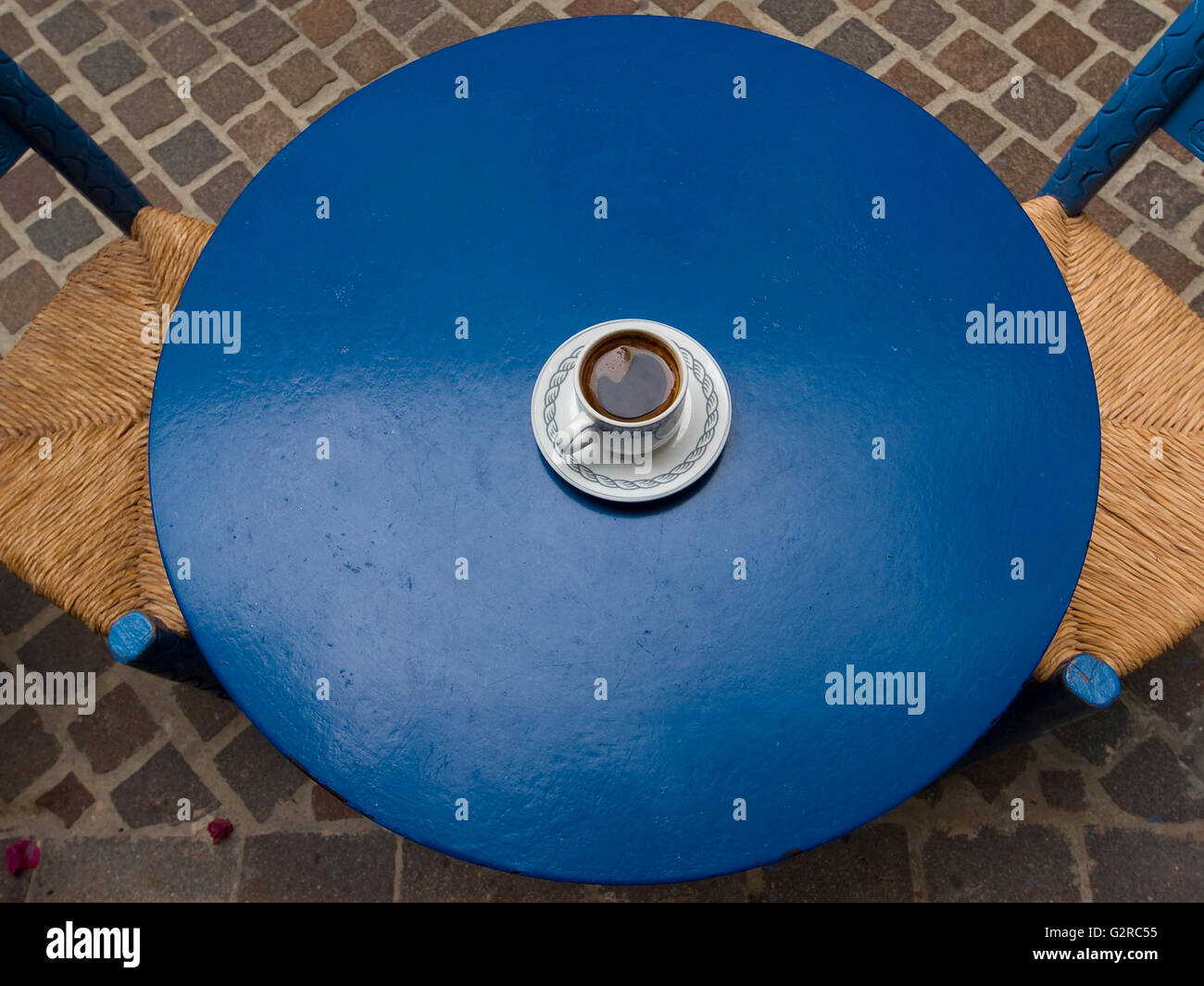 Round blue table with white coffee cup in middle Stock Photo - Alamy