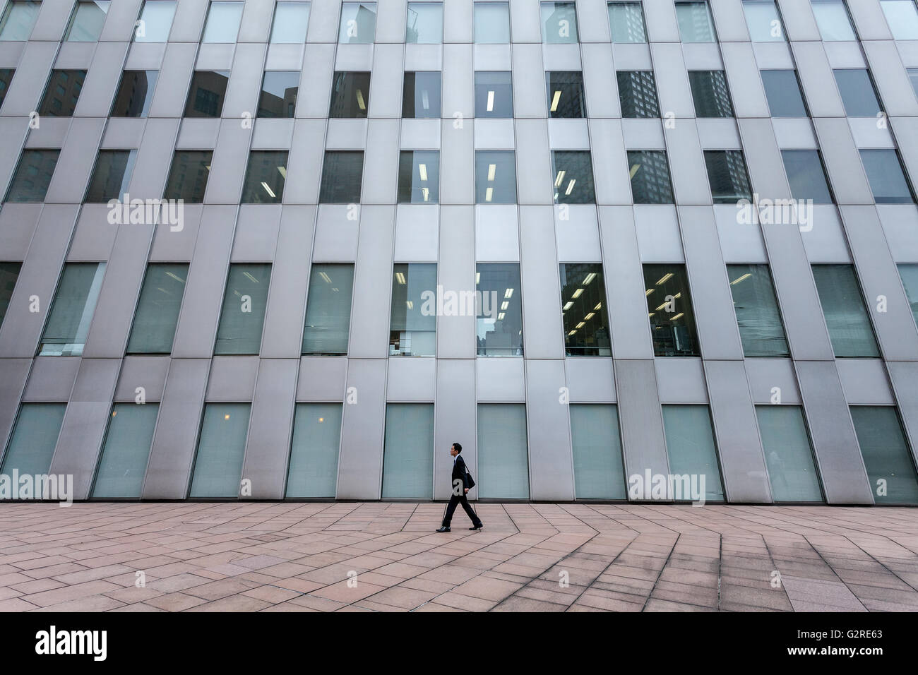 A Japanese male office worker or salaryman walks in front of an office ...