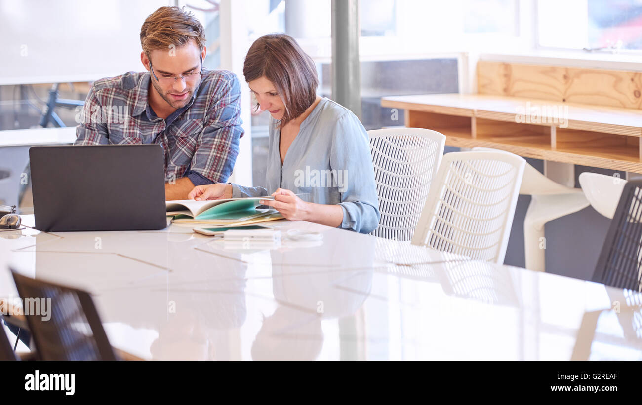 Adult couple working together at a conference table Stock Photo - Alamy