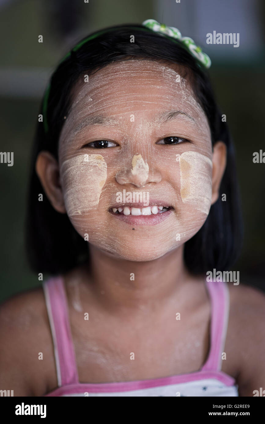 Portrait of a beautiful Burmese girl wearing traditional make-up ...