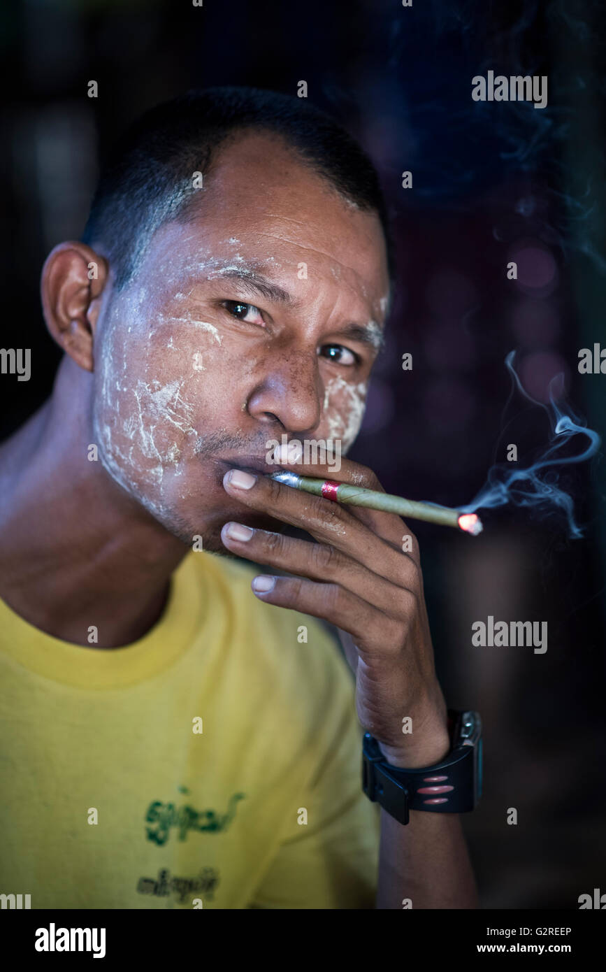 Portrait of a Burmese man smoking a cigarette, Dala, Yangon, Myanmar ...