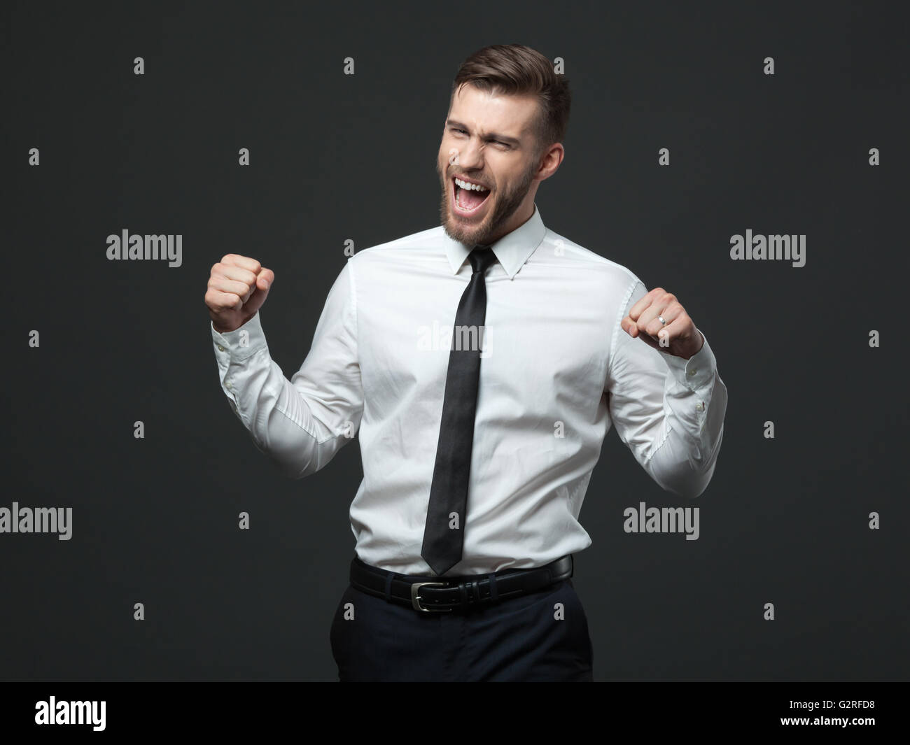 Yeah! The victory is mine! Handsome young businessman celebrating his ...