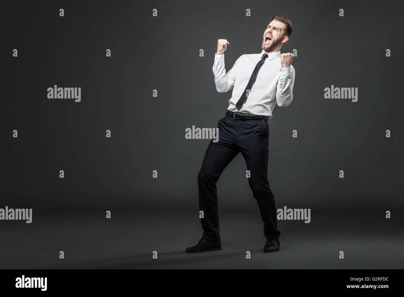 Yeah! The victory is mine! Handsome young businessman celebrating his ...