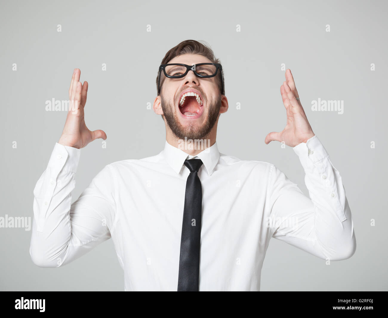 Why! Young businessman screaming - isolated on gray background Stock ...
