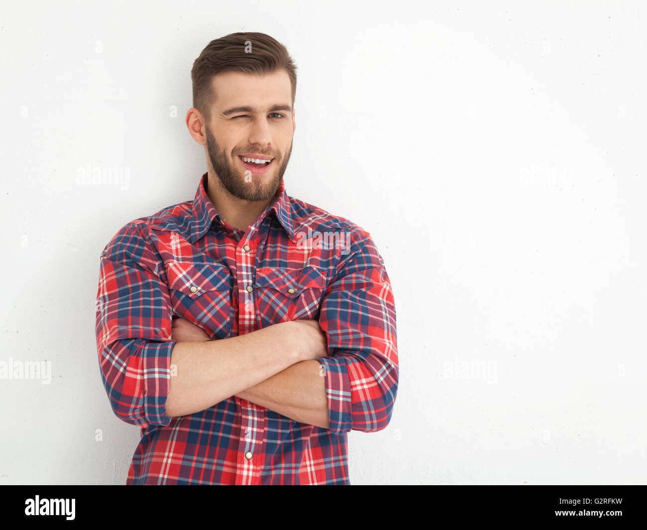 Portrait of handsome young guy standing against white wall Stock Photo ...