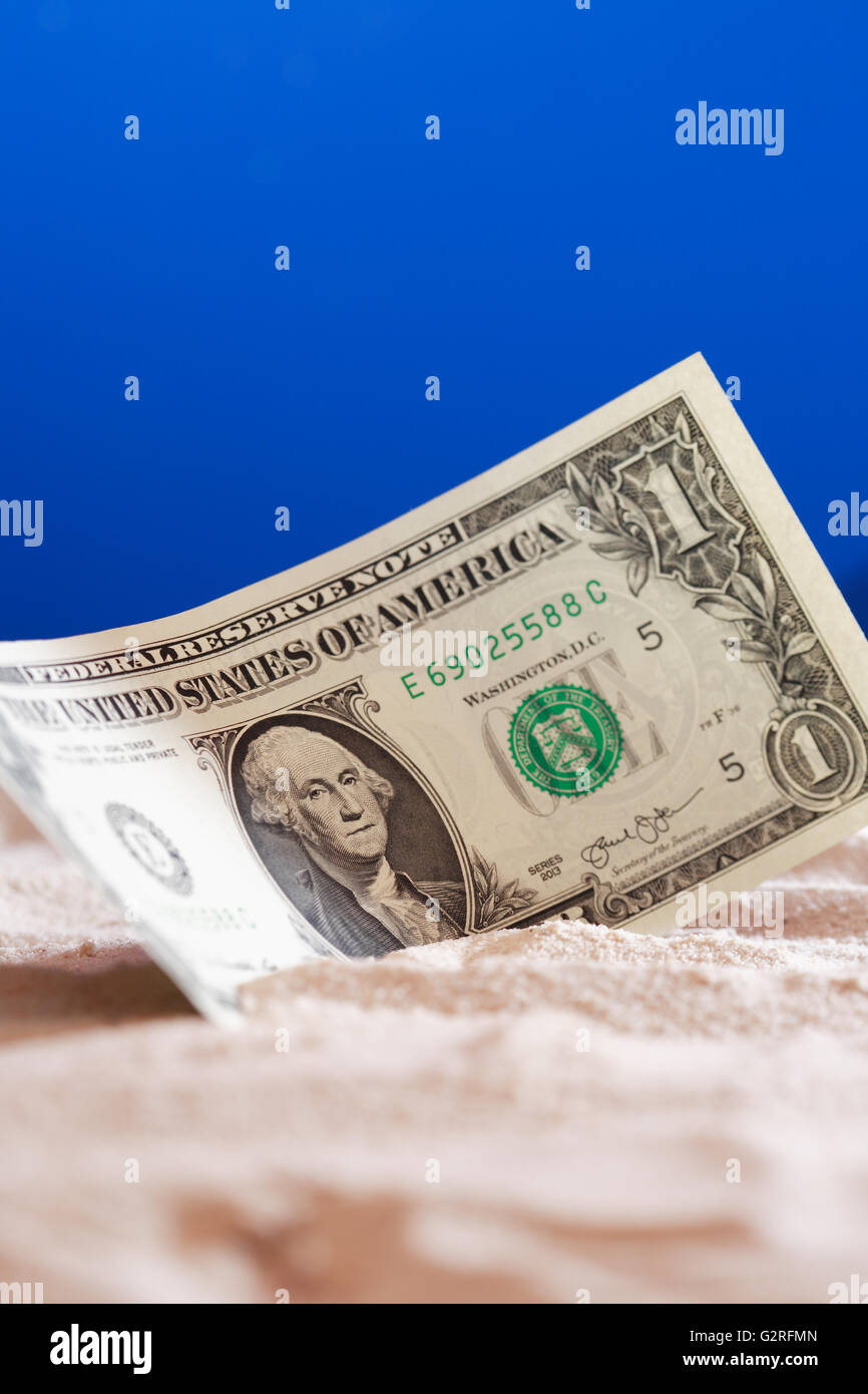 One dollar bank note on sand against blue background Stock Photo - Alamy