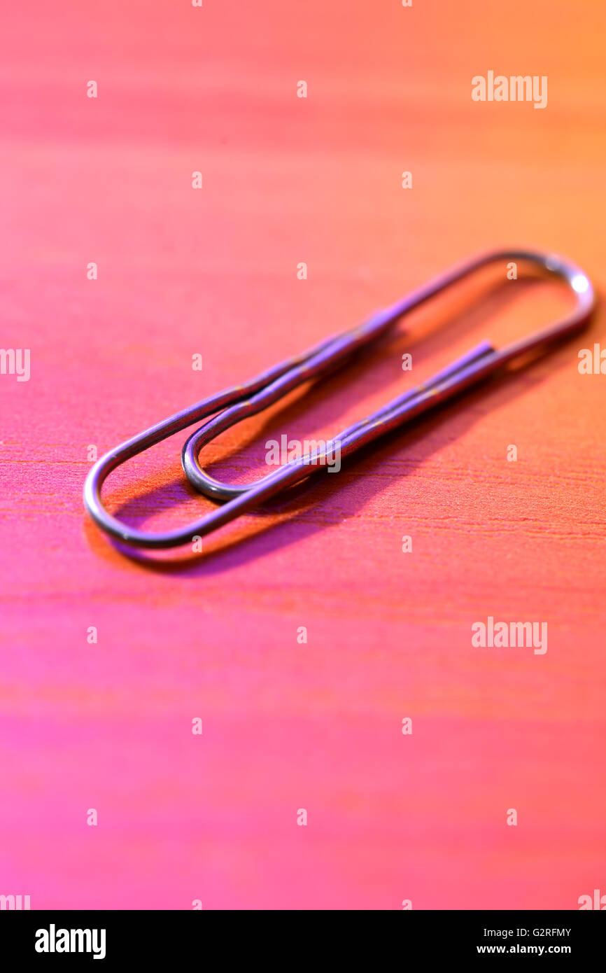 Closeup of metal paper clip on colorful background Stock Photo - Alamy